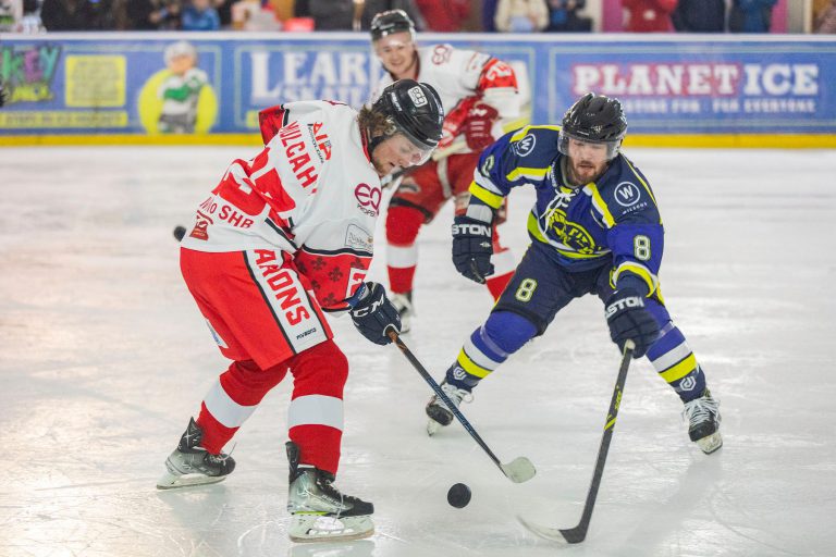 Daniel Mulcahy battles for the puck as brother Phil waits for his ...